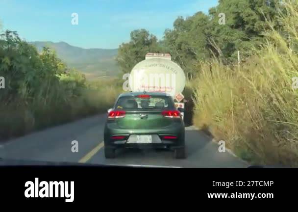 A tanker truck and cars waiting in a countryside traffic jam ...