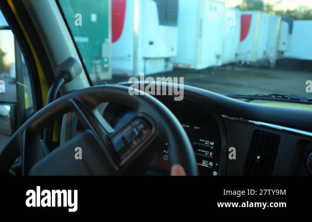Professional Semi Truck Driver sits in his truck and carries out cargo ...