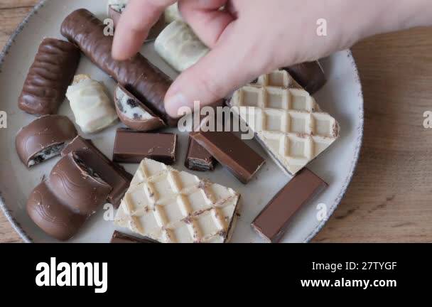 Hand is taking sweets from a plate. Chocolates and wafers Stock Video ...