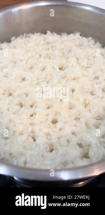 White rice boiling in the casserole dish. Boiling white rice in ...