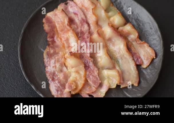 Delicious bacon in the form of slices with salt, spices and herbs on a ...