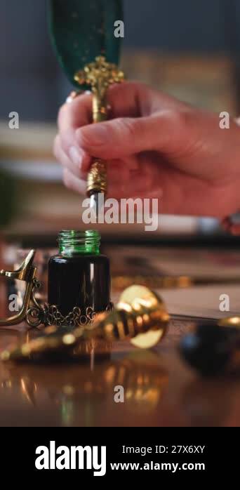 Woman with quill pen and ink. Girl dips quill into ink. Young woman ...