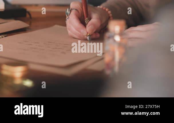 Close up of girl's hand writing calligraphy with ink pen. Professional ...
