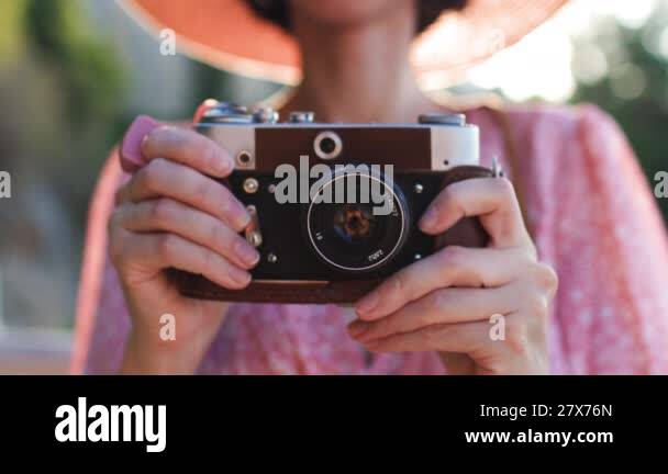 photographer with camera takes pictures outdoors. Beautiful young woman ...
