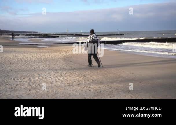 People walking along the North Sea coast in winter in January on a ...