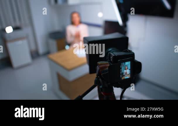 Blogger speaking to camera sitting at desk. Professional camera footage ...