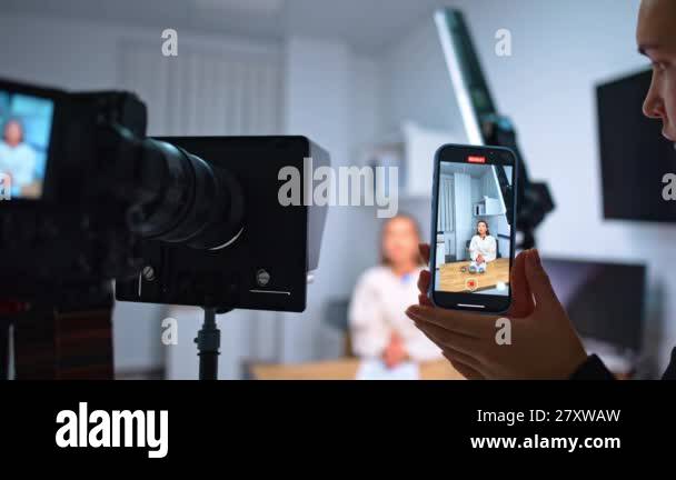 Professional camera and smartphone in girl's hand recording a female ...