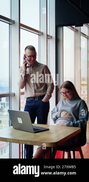 Pregnant lady working in the office sitting at desk with laptop. Woman ...