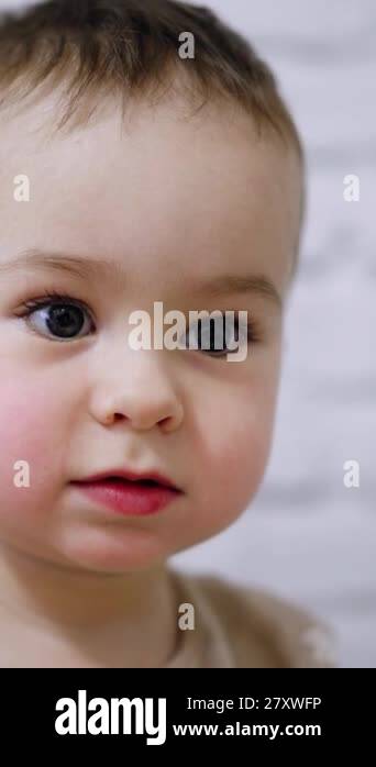 Adorable big-eyed baby boy with mousy hair. Portrait of a calm ...
