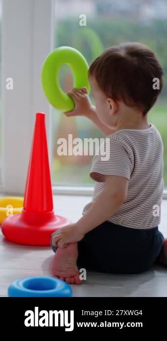 Caucasian toddler sits on the floor his back to camera. Lovely child ...