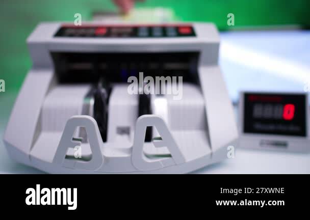 Money placed into automatic cash counting machine. Green hundred euro ...