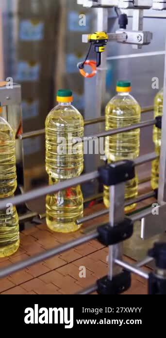 Modern factory of food oil production. Row of full plastic bottles of ...