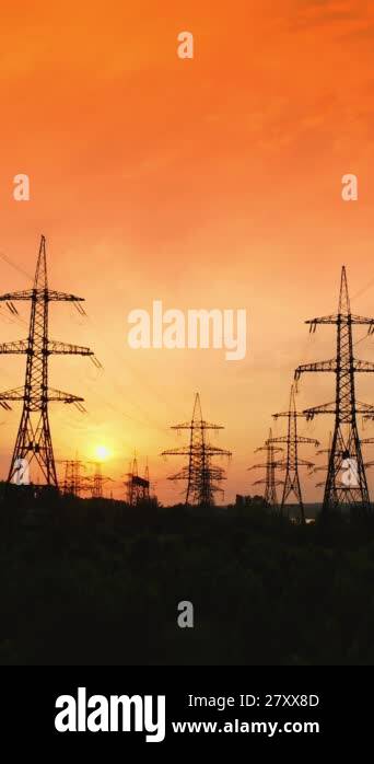 Transmission lines against red evening sky. High-voltage electricity ...