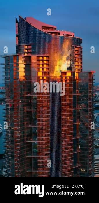 Golden light of setting sky reflects in the mirror windows of ...