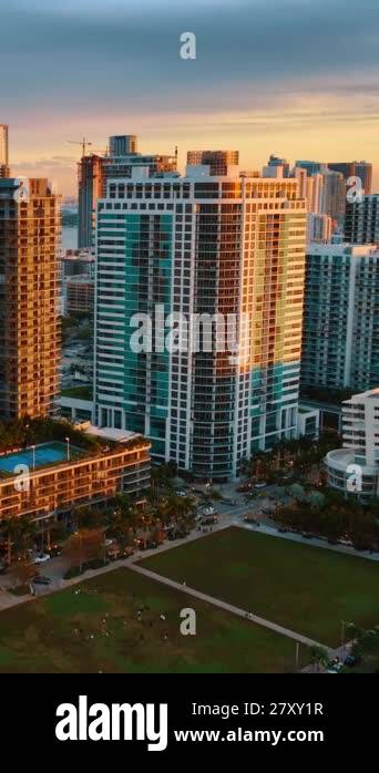 Bright orange light of setting sun on the facades of the high-rise ...