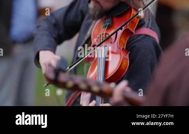 A man playing a violin with a strap around his neck. Concept of passion ...