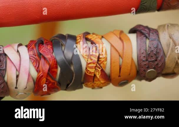 A collection of leather bracelets with different designs and colors ...