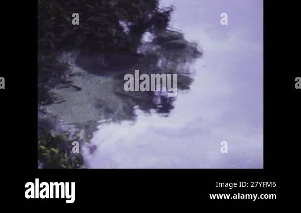 Denpasar, bali june 1985: purple-tinted water reflecting lush ...
