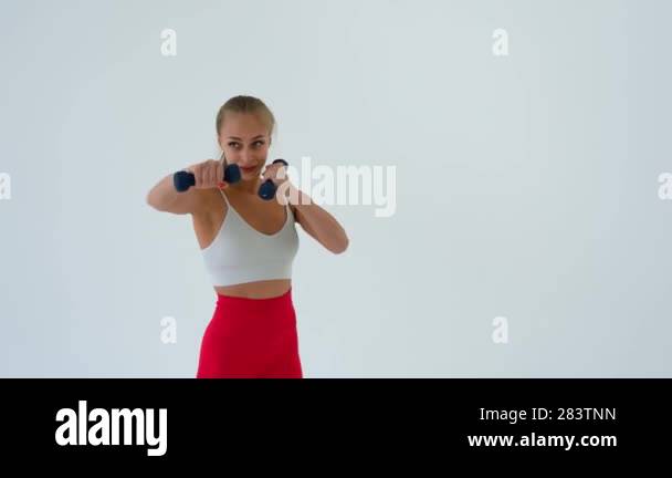 Young woman doing boxing exercises with dumbbells on white background ...