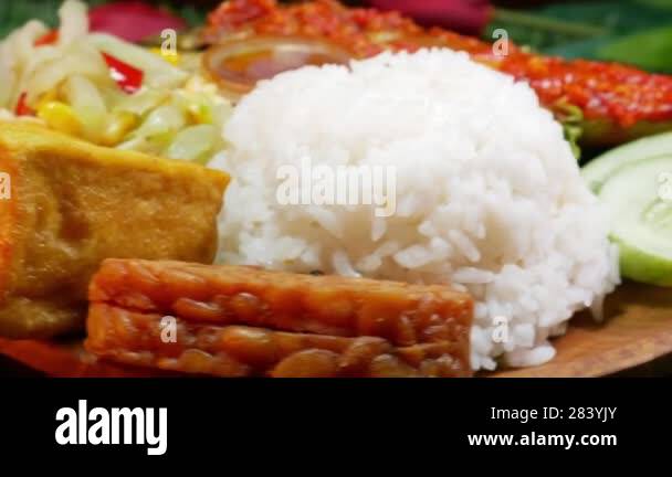 Close up a plate of warm white rice served with fried fish in spicy red ...