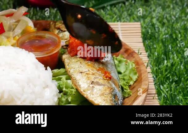 Close up A complete meal featuring white rice, fried fish with red ...