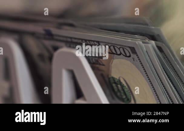 Close up of a stack of cash featuring multiple hundred dollar bills ...