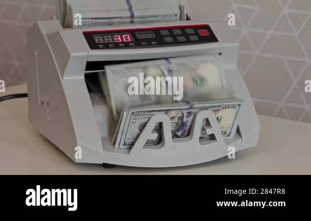 A currency counting machine displays a precise count while processing ...