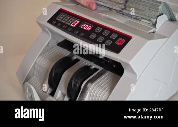A person is operating a currency counting machine that efficiently ...