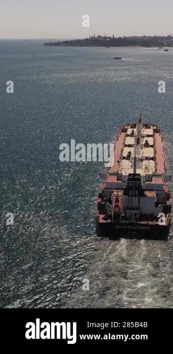 Aerial shot of a large transport ship crossing the Bosphorus, a city by ...