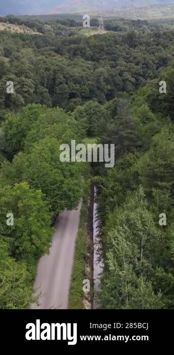 Aerial view asphalt road and green forest, road in countryside leads to village, ecosystem and ...