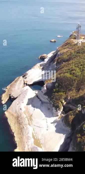 Shooting from the drone of the immense white cliff on the turquoise sea ...