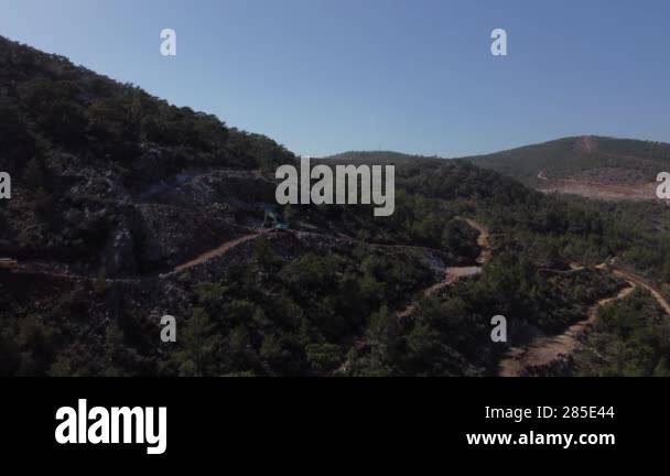 Overhead view of orange earthmoving machine doing roadwork removing ...