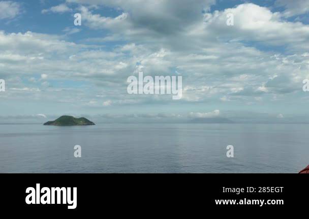 Gentle waves meet a soft, cloud-speckled sky in a peaceful, idyllic ...