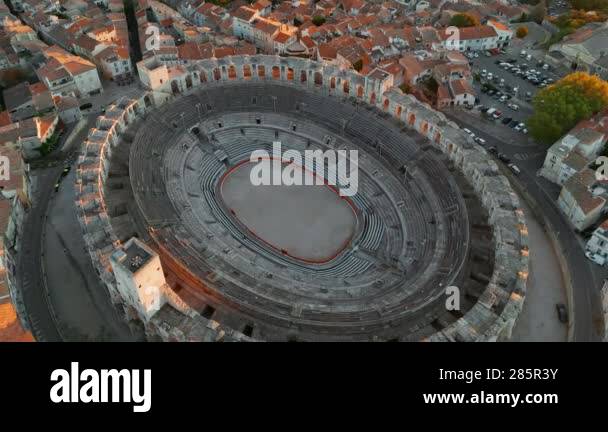 Cityscape of Arles at sunrise, southern France. HIstoric buildings, Arles Amphitheatre and Rhone ...
