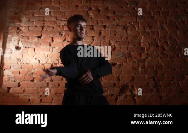 Young man in black clothes dancing hip hop against red brick wall Stock ...