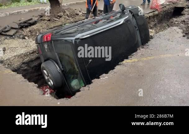 Accident on the road: a passenger car has fallen through the asphalt ...