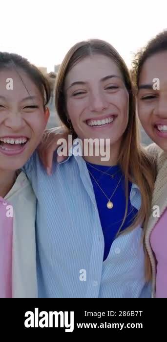 Vertical HD video. Three diverse cheerful generation z girls smiling at ...