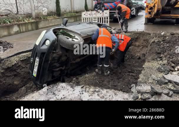 Accident on the road: a passenger car has fallen through the asphalt ...