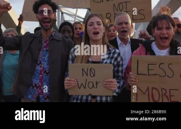 Activists protesting against war, holding signs and chanting slogans ...