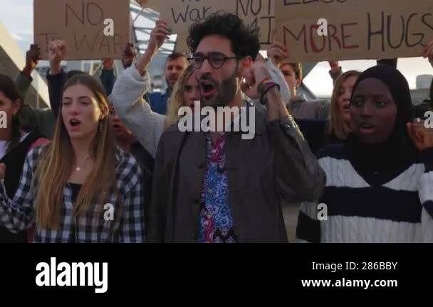 Multicultural activists peacefully marching, holding placards ...