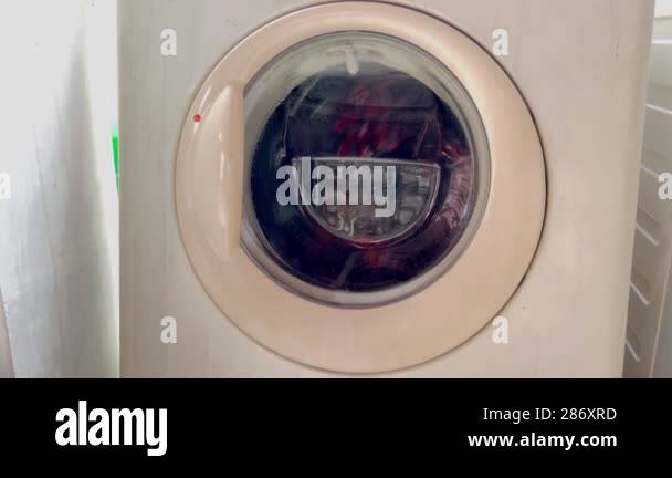Close-up of a washing machine in action, spinning and cleaning clothes ...