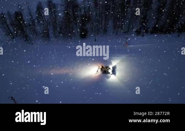 Aerial view of working snowcat on snowy alpine ski slope at winter ...