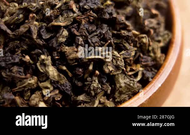 Dried Gunpowder green tea leaves in wooden bowl. Aromatic Chinese hot ...