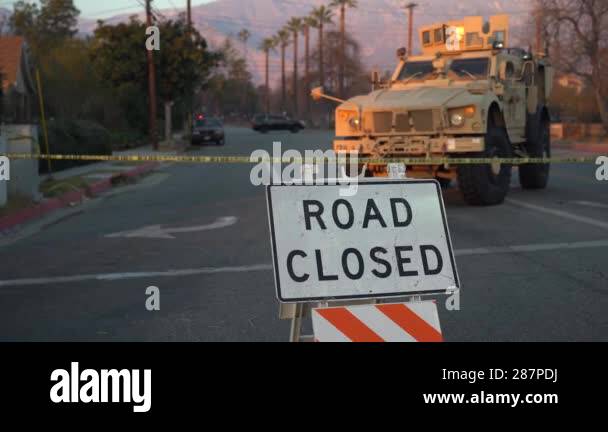 A "Road Closed" sign and traffic cone stand prominently in the ...