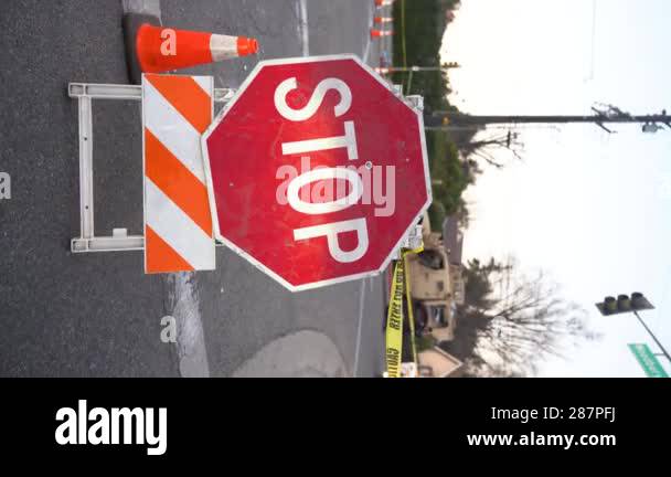 Vertical. A prominent "Stop" sign with traffic cones marks a road ...