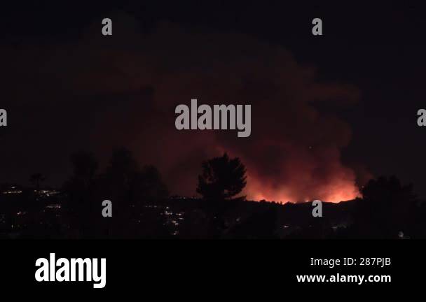 Nighttime footage of a massive wildfire burning on the hills near ...