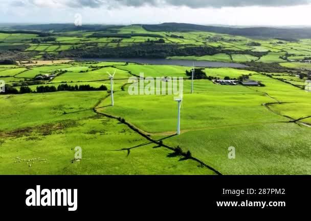 Small windmills farm for energy production on beautiful green field ...