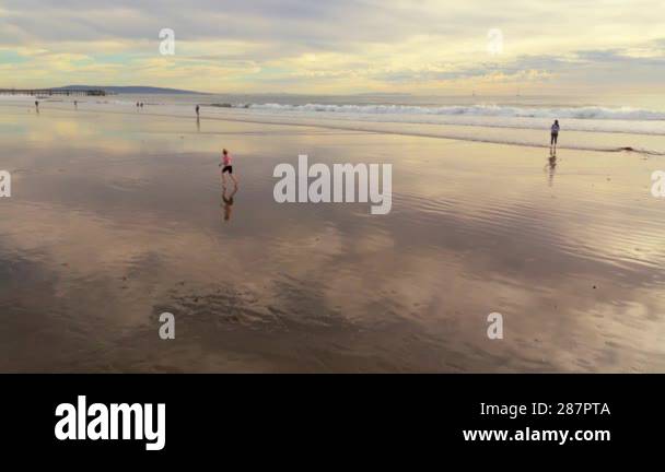 Tranquil beach setting featuring gentle waves and reflective sand, with ...