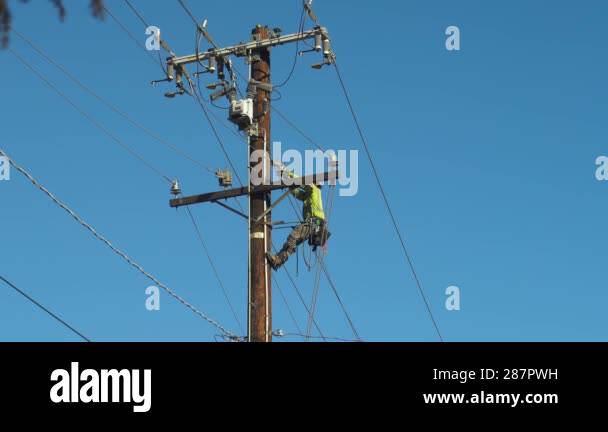 A dedicated utility worker is performing essential maintenance on ...