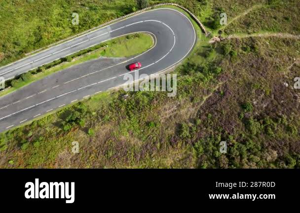Cars driving through sharp turn on winding zig zag serpentine road in ...